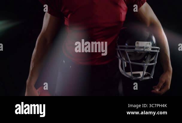 Preparing for game, football player in red jersey showing intense focus ...