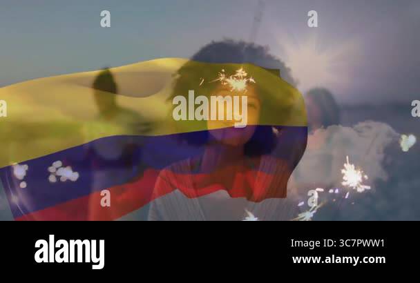 Holding sparklers, woman celebrating over Colombian flag at sunset with ...