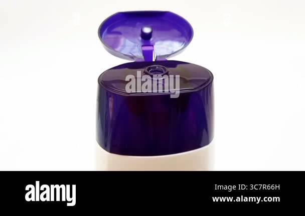 An open plastic bottle cap rotating on a white background, navy blue ...