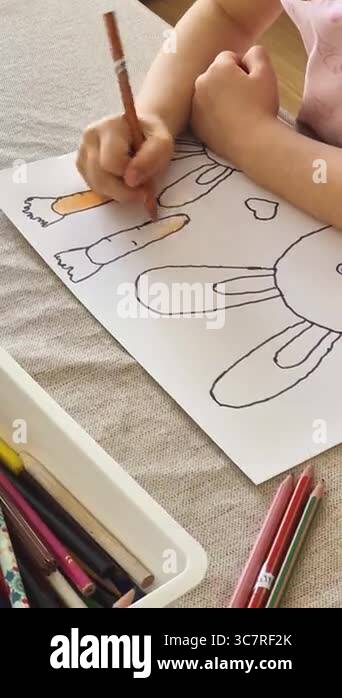 A child paints Easter-themed drawings of bunnies, carrots and hearts ...