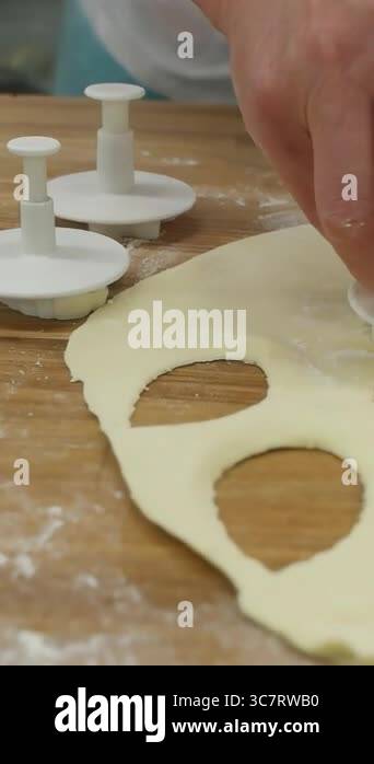Womens hands choose the shape and cut out cookie cutters from the dough ...