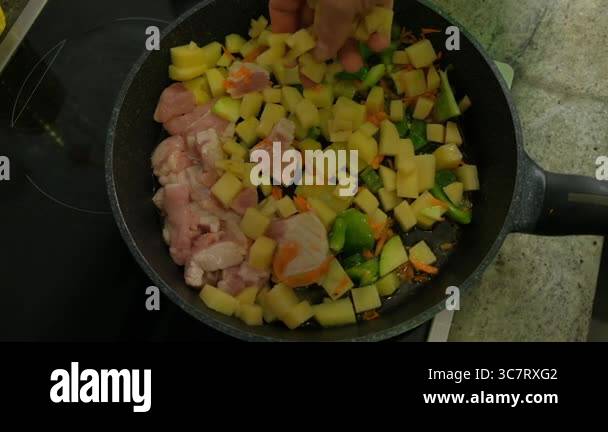 Meat and vegetables sizzle and cook in a frying pan close-up Stock ...