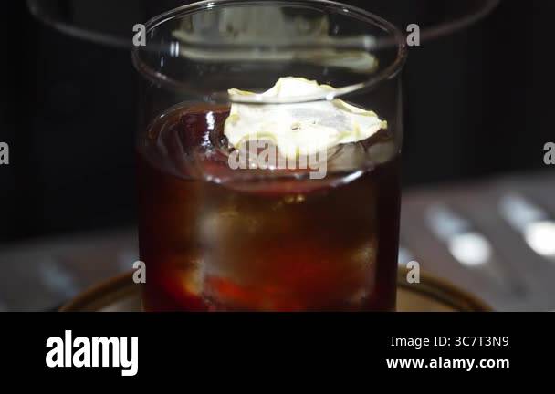 Bartender opening covered glass cocktail whiskey in Old fashioned with ...