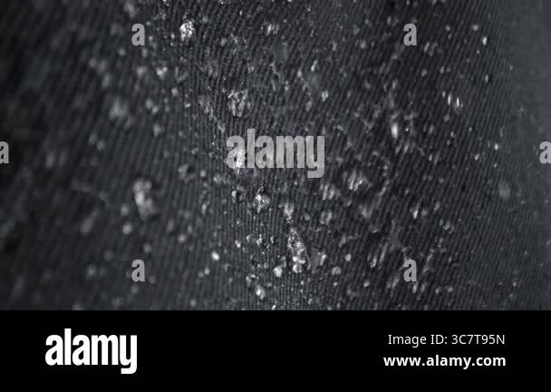 Super Slow Motion Detail Shot of Water Flow Down on Waterproof Black ...