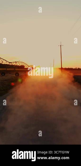 Dusty road. sunset over farm field. dusty, dirt road along an ...