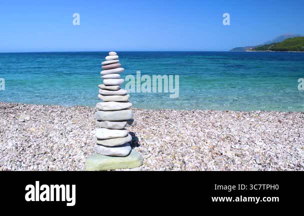Sea pebble turret for good luck on beach at background of a calm blue ...