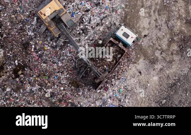 Heavy machinery is actively sorting and processing waste at a landfill ...
