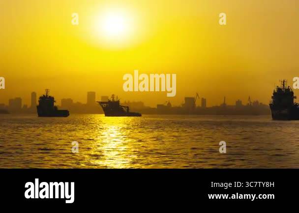 The scene features many ships and large vessels in the sea, illuminated ...