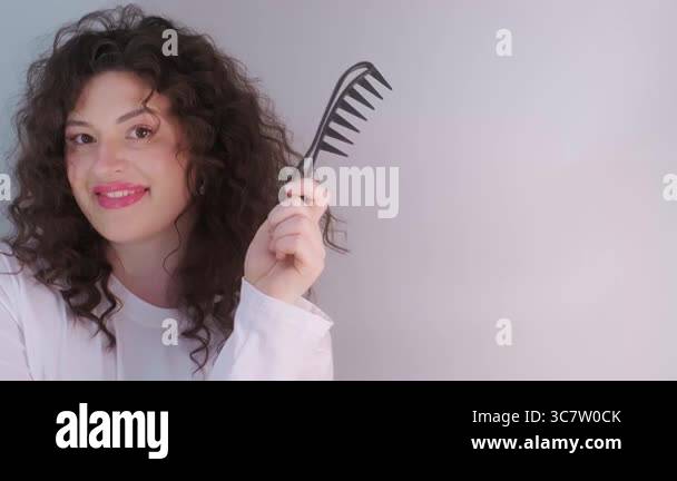 Gentle hair care: woman combing her thick curls and massaging her scalp ...