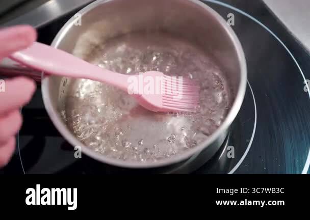 Preparing syrup for soaking cake crust, sugar boiling. Pastry chef ...