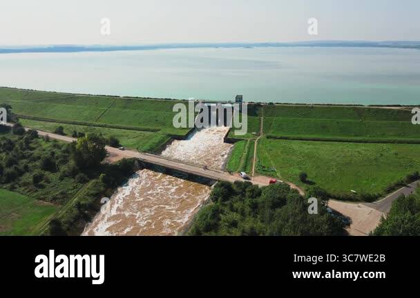 Aerial view of large dam discharging water into channel, managing water ...