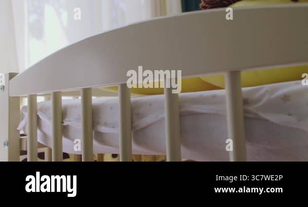 Wooden crib with protection borders in nursery room. Modern baby bed ...