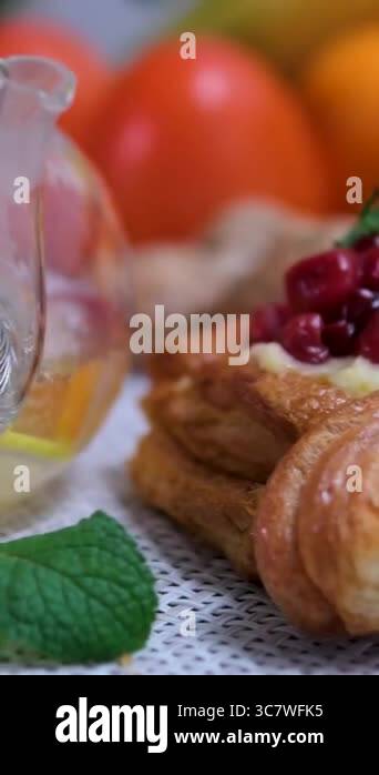 Rotating view of spiced hot lemon tea in a stylish glass cup with ...