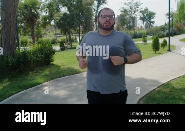 Man trying to lose weight having sports training in the park, running ...