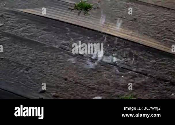 Flowing water from broken pipe on the street and puddle on wooden ...