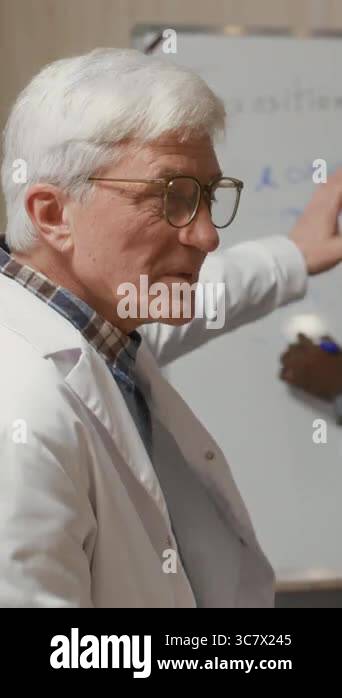 Vertical shot of senior male clinical professor pointing at board ...