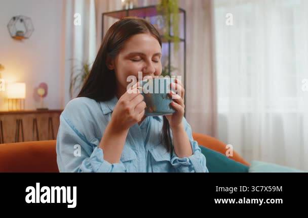 Beautiful smiling happy Caucasian young woman drinking a cup of warm ...