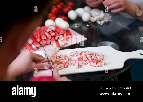 Hands cutting crab meat, knife chopping surimi sticks, culinary routine ...
