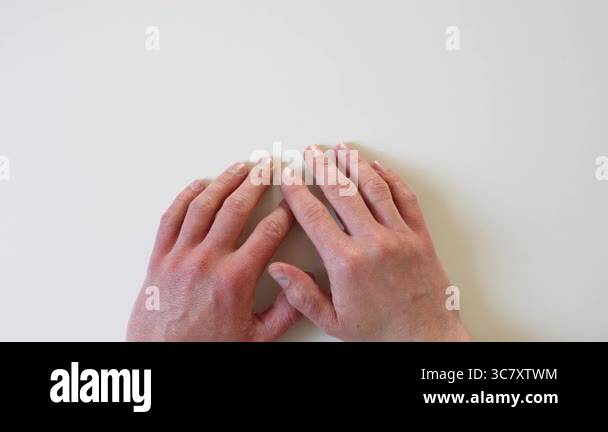 Overhead view of two male hands moving slightly on white background ...