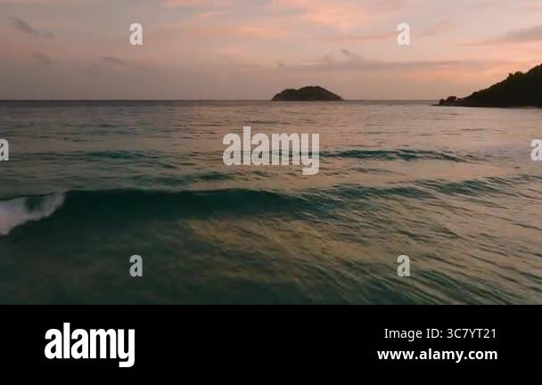 Ocean waves and a tropical island at sunset. Seychelles, Vache Island ...