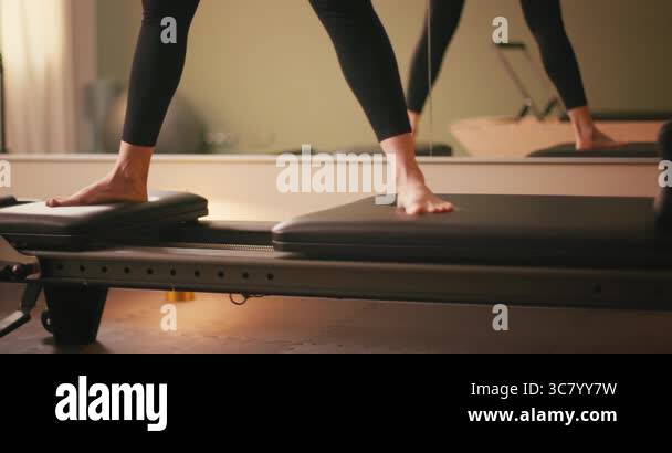 Close up on womans feet doing pilates exercise on Pilates Reformer for ...