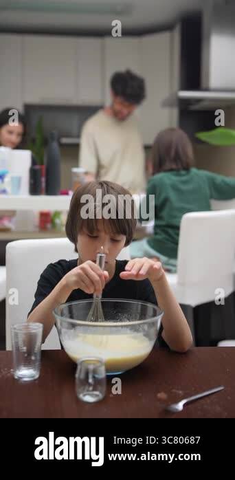 A joyful scene of children whisking batter, engaging in cooking fun ...