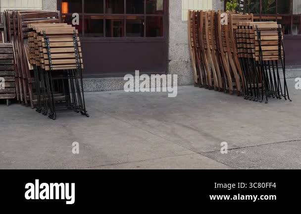 Neatly aligned chairs and tables wait outside a tiled wall eatery in ...
