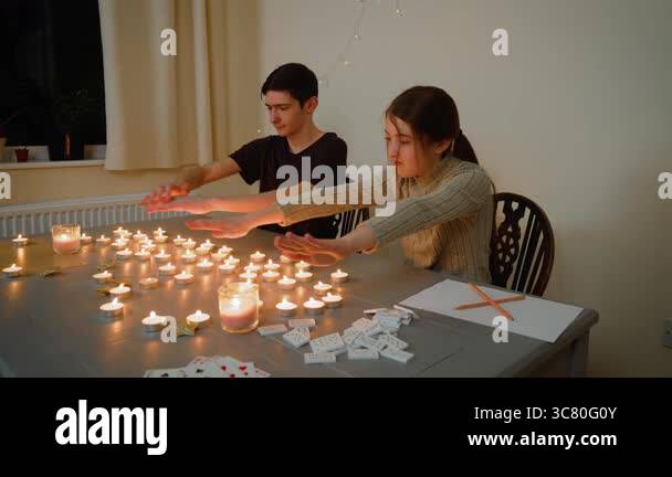 Kids waving hands over candles performing magical movements. Boy and ...