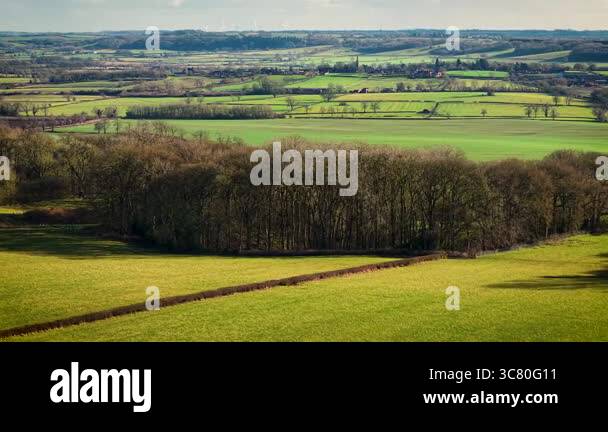 Lush green fields and dense woodland stretching across rolling ...