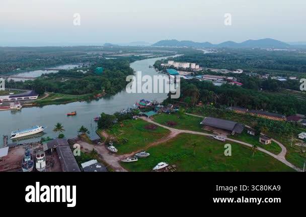 Meandering river flowing through green forests between industrial ...