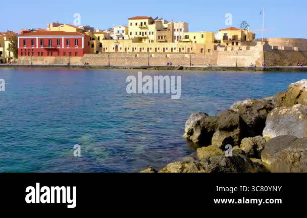 Blue waters of the Aegean Sea and historic buildings at the entrance to ...