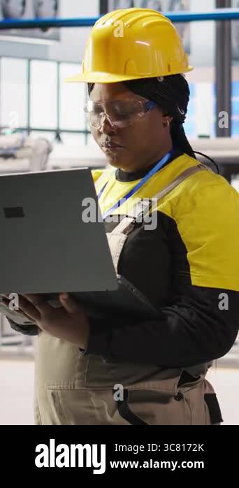 Vertical video Solar panels factory engineer analyzing data from IoT sensors to refine equipment ...