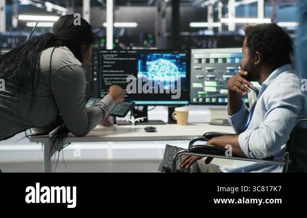 Admin in wheelchair and data center coworker working together using AI ...