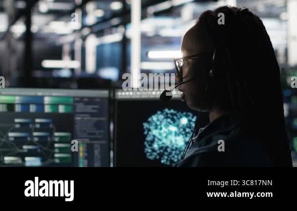 Data center employee uses audio headset and visual programming dashboard to troubleshoot client ...