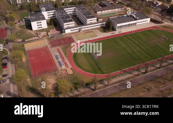 School Complex with Sports Fields and Urban Landscape - Aerial View ...