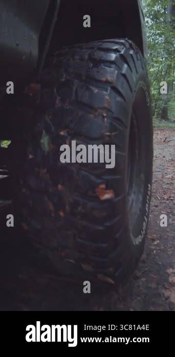 Close up speed wheels of cars are driving on the trail in the forest ...