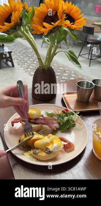 Shot of poached egg cut with knife and burst yolk dripping on breakfast ...