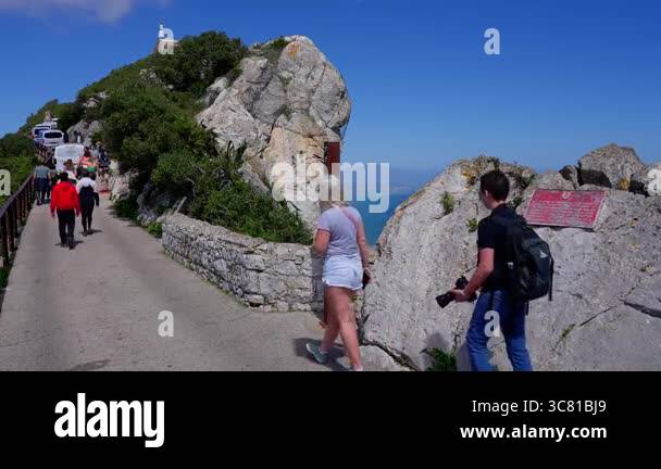 Tourists enjoying a walk on a scenic road in the Rock of Gibraltar ...