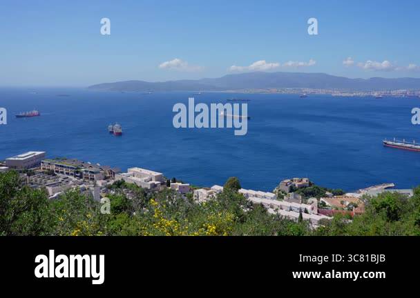 Cargo ships sailing on the Strait of Gibraltar with the city of ...