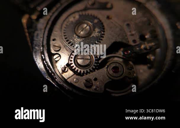 Close up of inner mechanism of a vintage watch with changing lighting ...