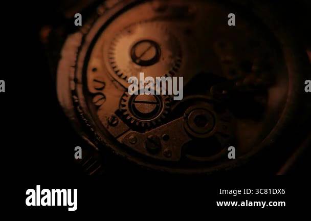 Close up of inner mechanism of a vintage watch with changing lighting ...