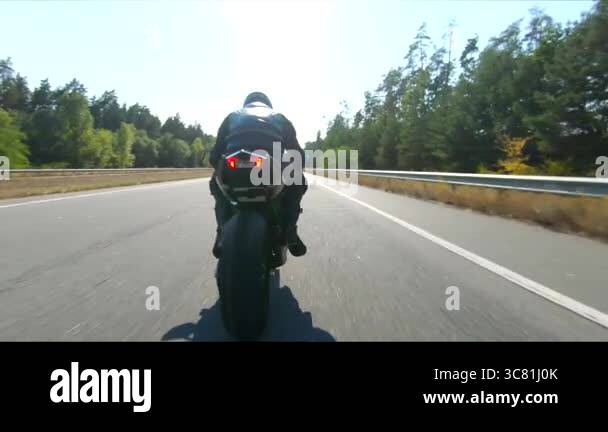 Aerial shot of man riding fast on modern sport motorbike at highway ...