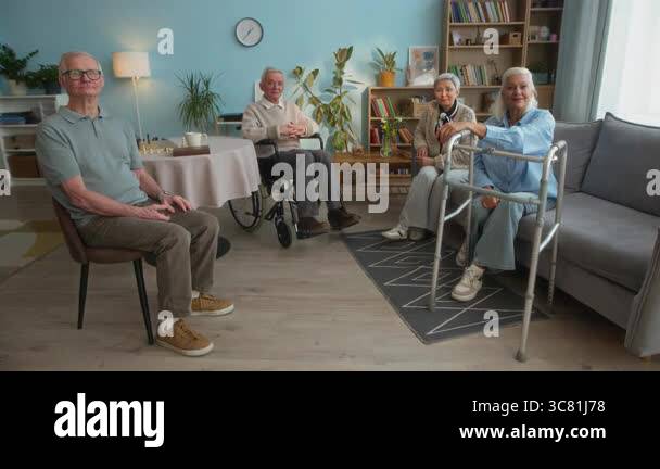 Four seniors, seated and smiling, posing for camera in bright nursing ...