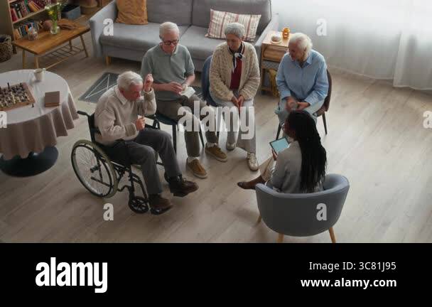 Seniors participating in group therapy session led by young Black ...