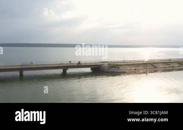 Aerial view to biker riding on motorbike at dam route with sunshine at ...