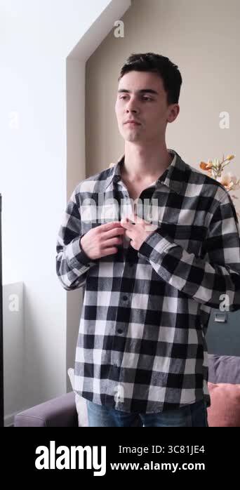 Concentrated young adult Caucasian man button shirt while looking in ...