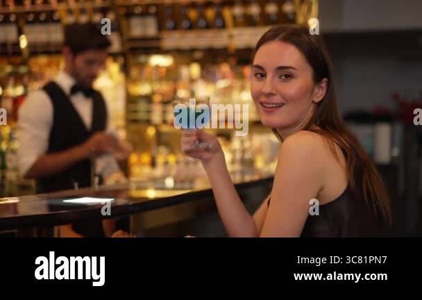 Sitting beautiful woman guest looking at camera to pose with drinking ...