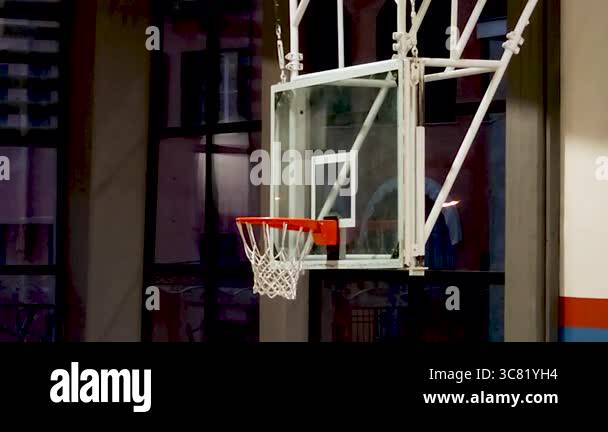 A basketball passing through the hoop in an indoor environment, with ...