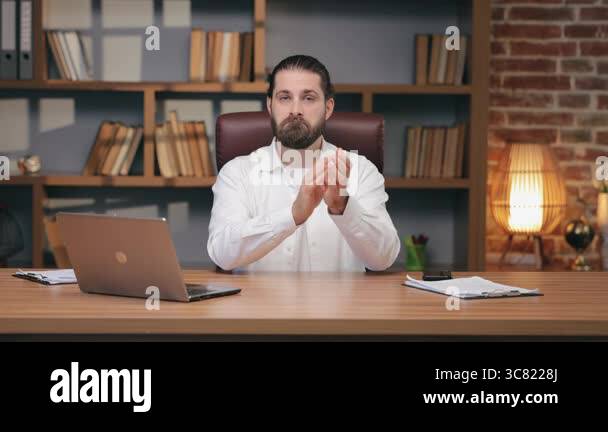 Serious Caucasian guy in white shirt clapping slowly with neutral face ...