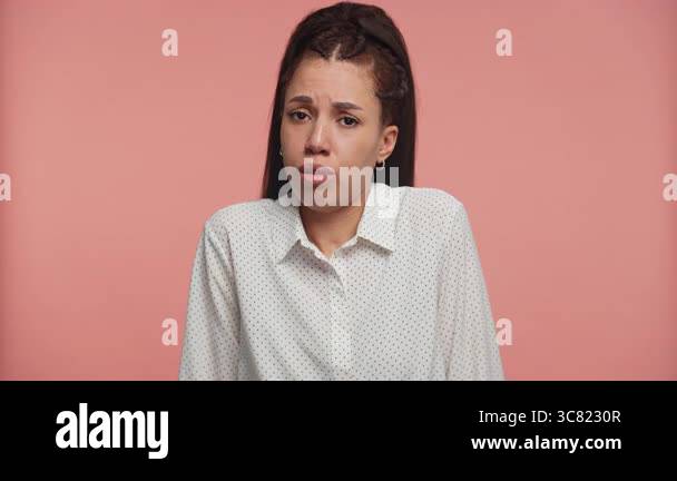 Young woman looking confused and slightly shrugging, expressing ...